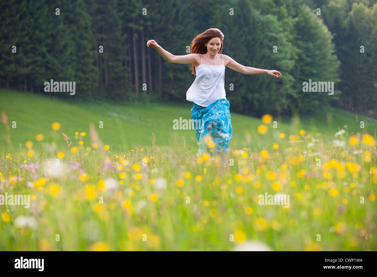 Austria, Young woman running in field of flowers Stock Photo - Alamy