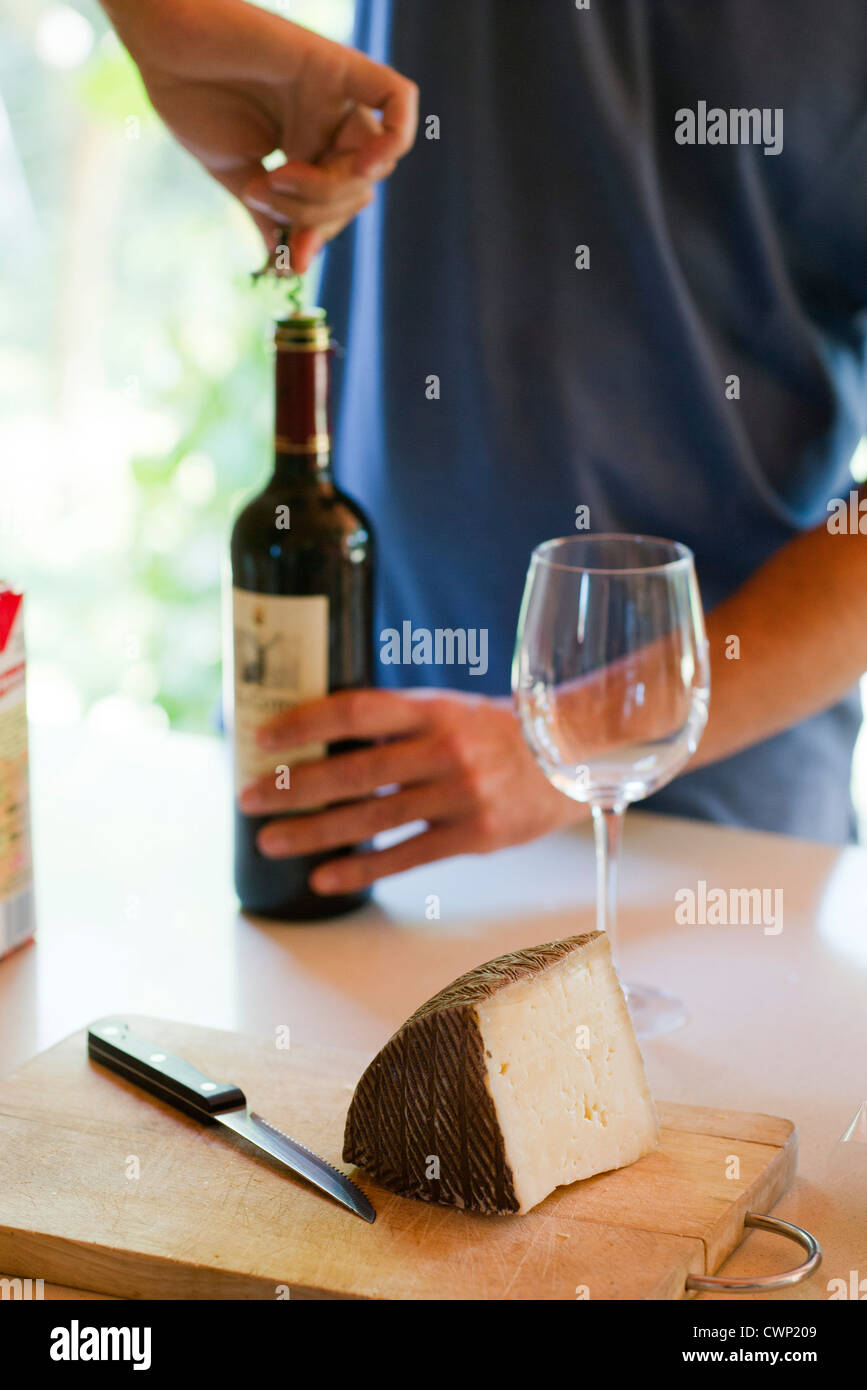 Man uncorking wine bottle, cropped Stock Photo - Alamy
