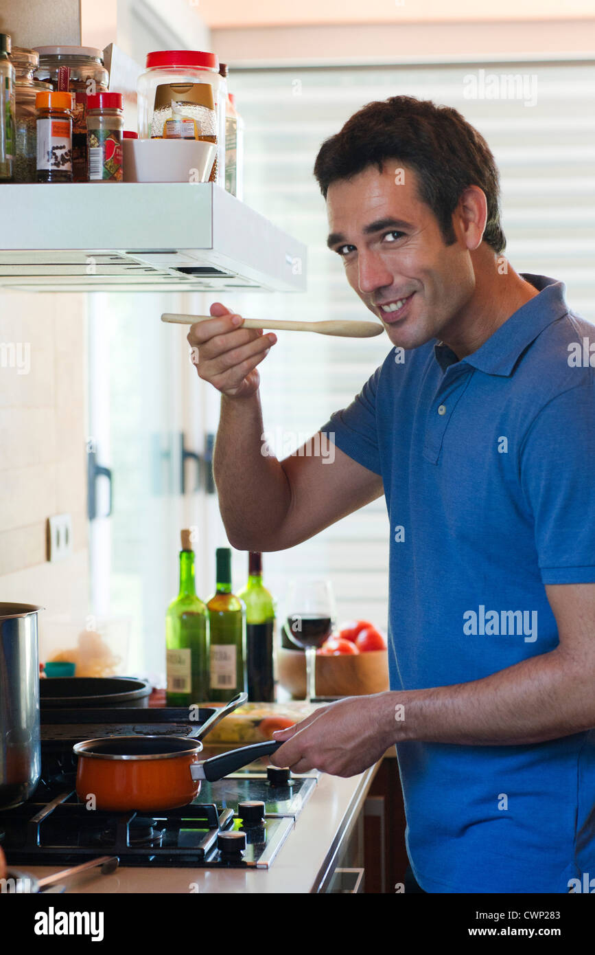 Man cooking in kitchen, smiling at camera Stock Photo - Alamy