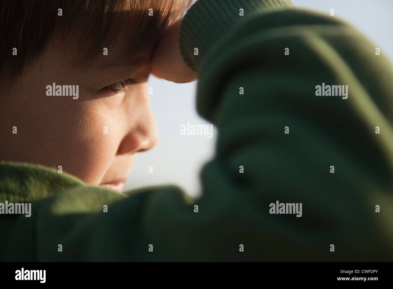 Boy shading eyes, side view Stock Photo - Alamy