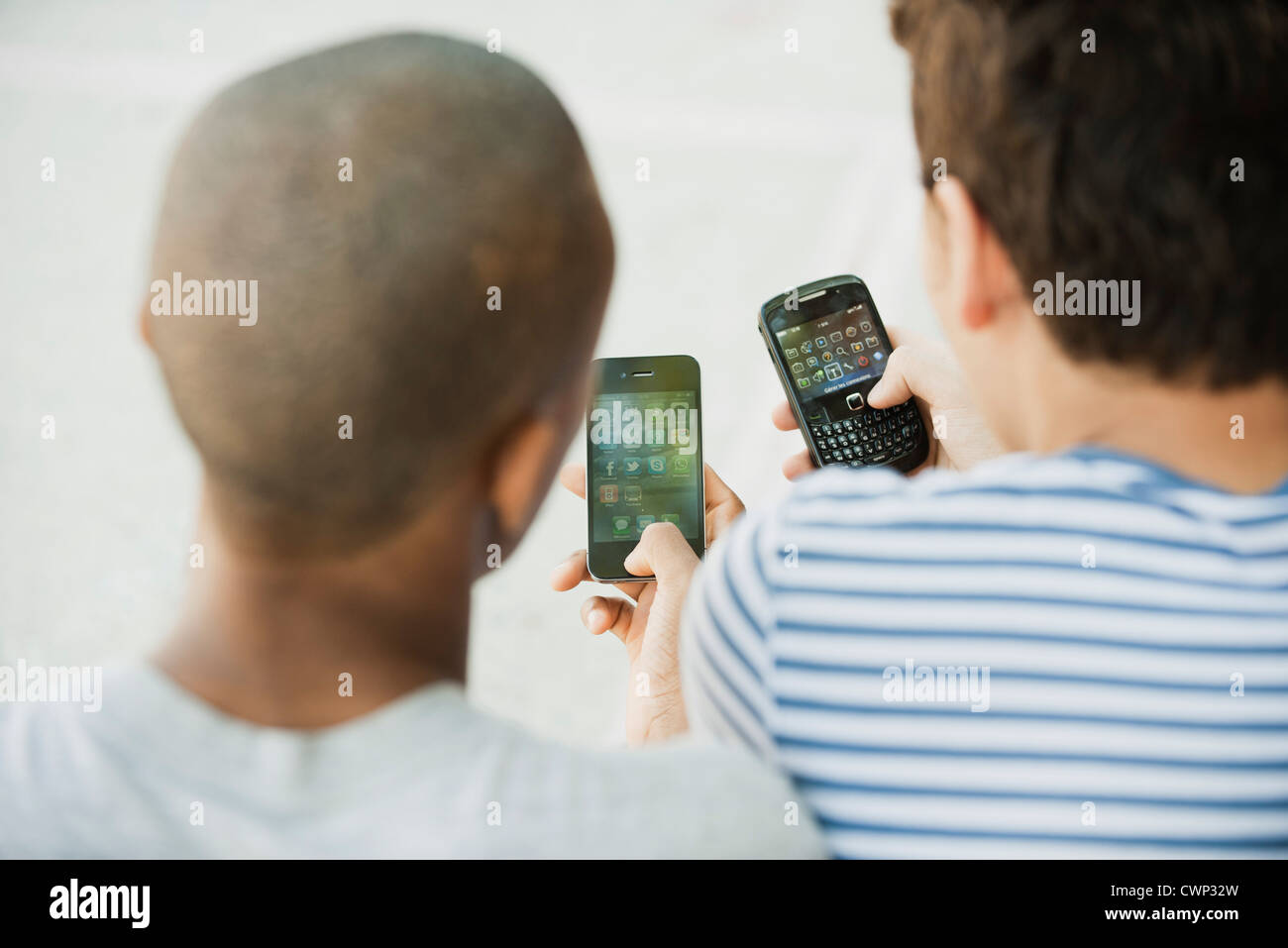 Young men using cell phones, rear view Stock Photo - Alamy