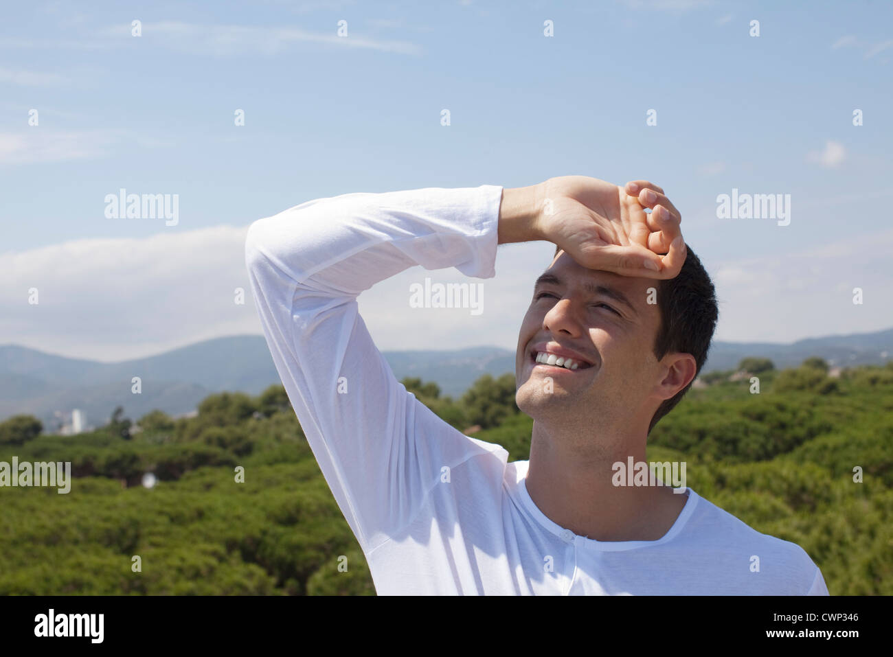 Man shading eyes from sun Stock Photo - Alamy