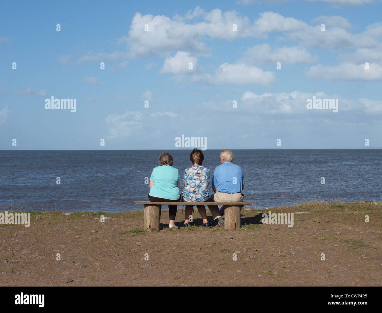 Three older people sitting on bench overlooking Bristol Channel ...