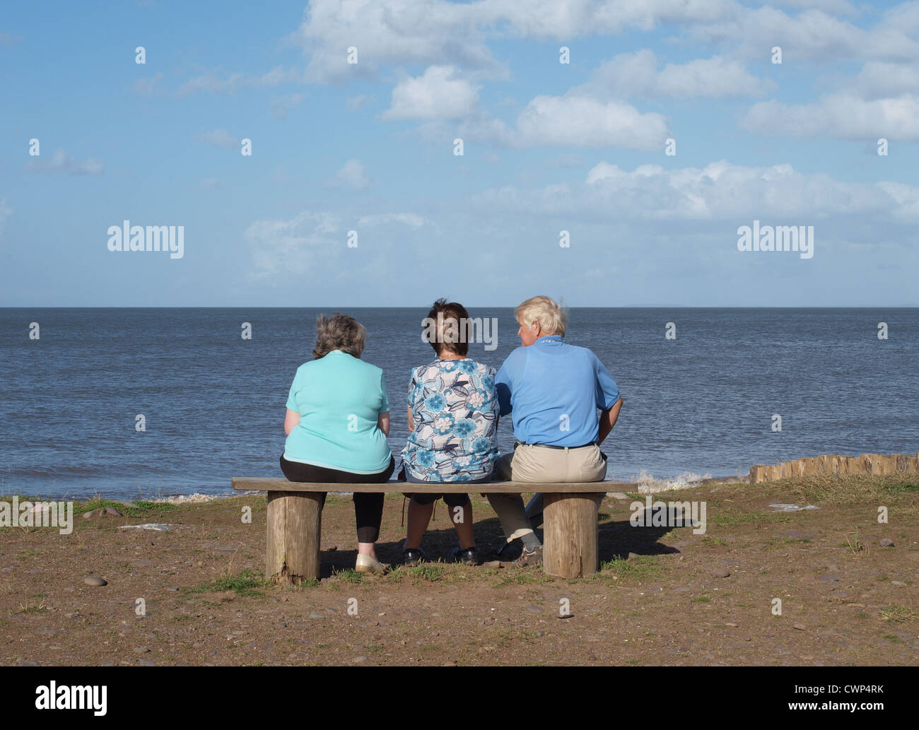 Three older people sitting on bench overlooking Bristol Channel.Dunster ...