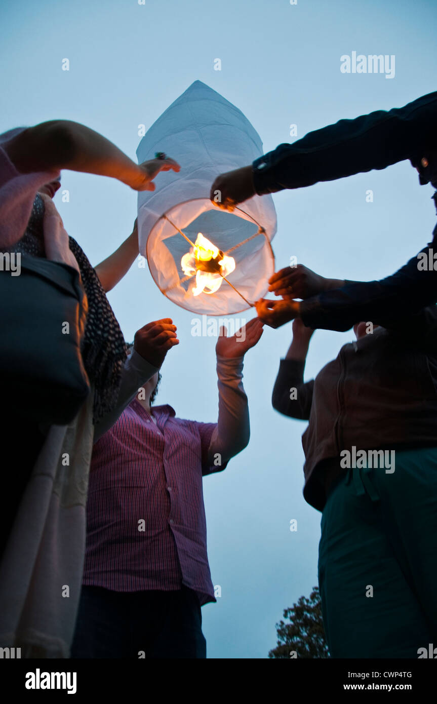 People launching a Chinese paper lantern Stock Photo - Alamy