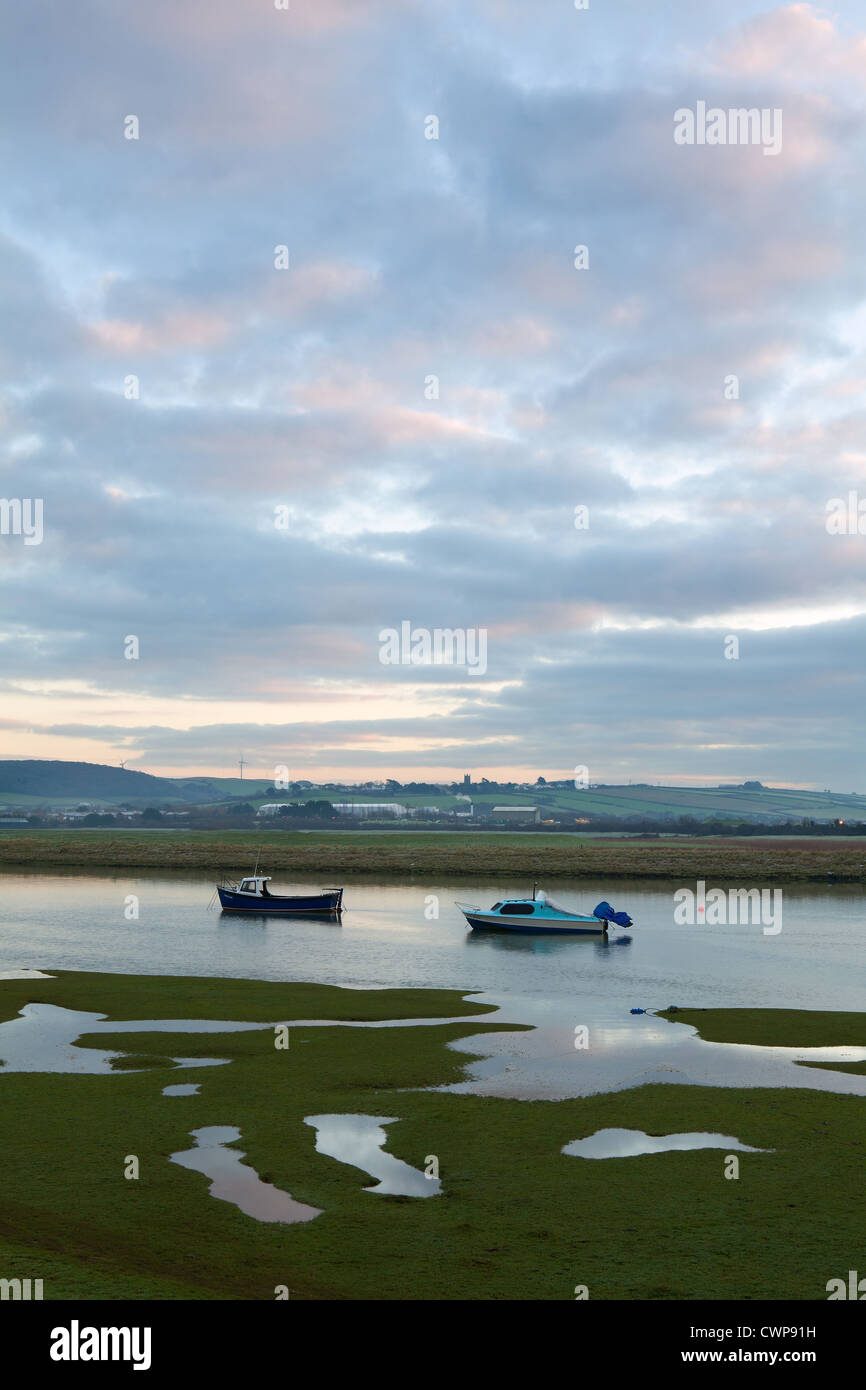Two small boats rising with incoming tide on tidal stretch of river at ...