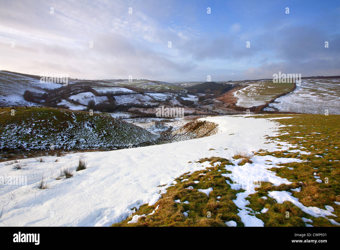 View of lingering snow on moorland hills and fields in late afternoon ...