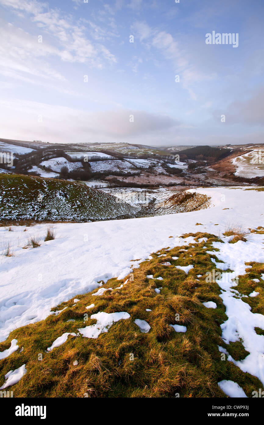 View of lingering snow on moorland hills and fields in late afternoon ...