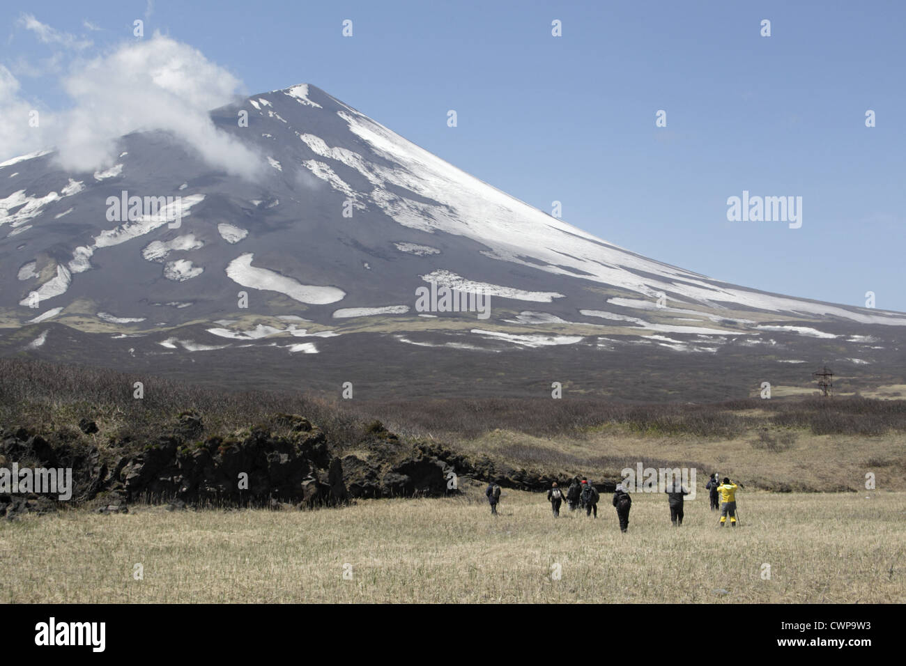 View of tourists and volcano, Mount Alaid, Atlasova Island, Kuril ...