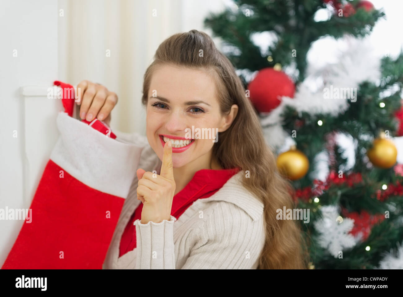 Woman putting beautiful christmas gift hi-res stock photography and ...
