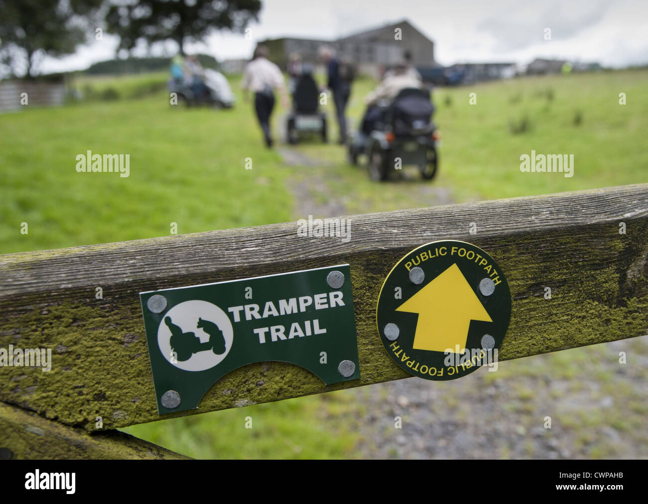 'Tramper Trail' and 'Public Footpath' signs on gate, people with ...