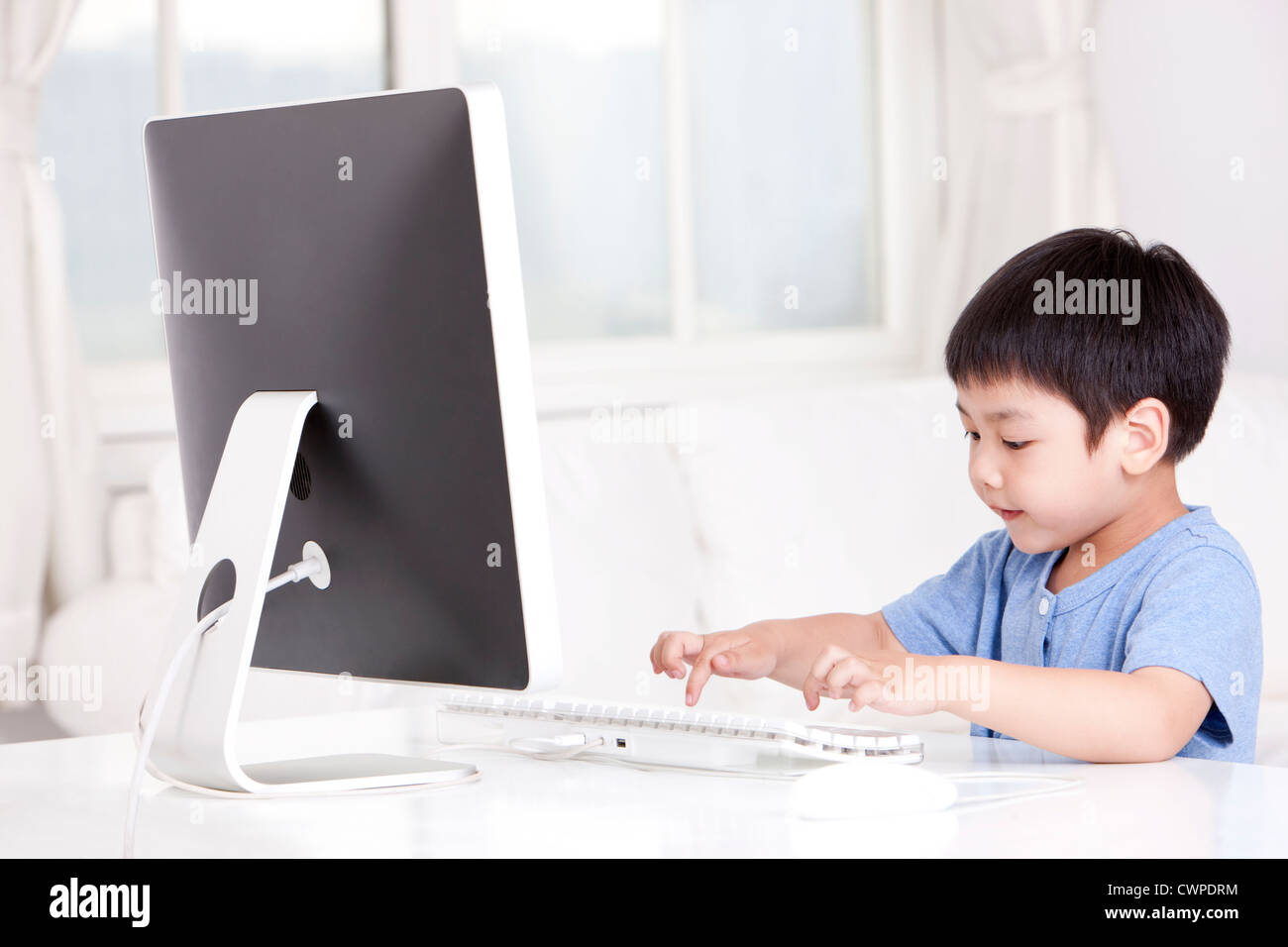 Boy using computer at home Stock Photo - Alamy