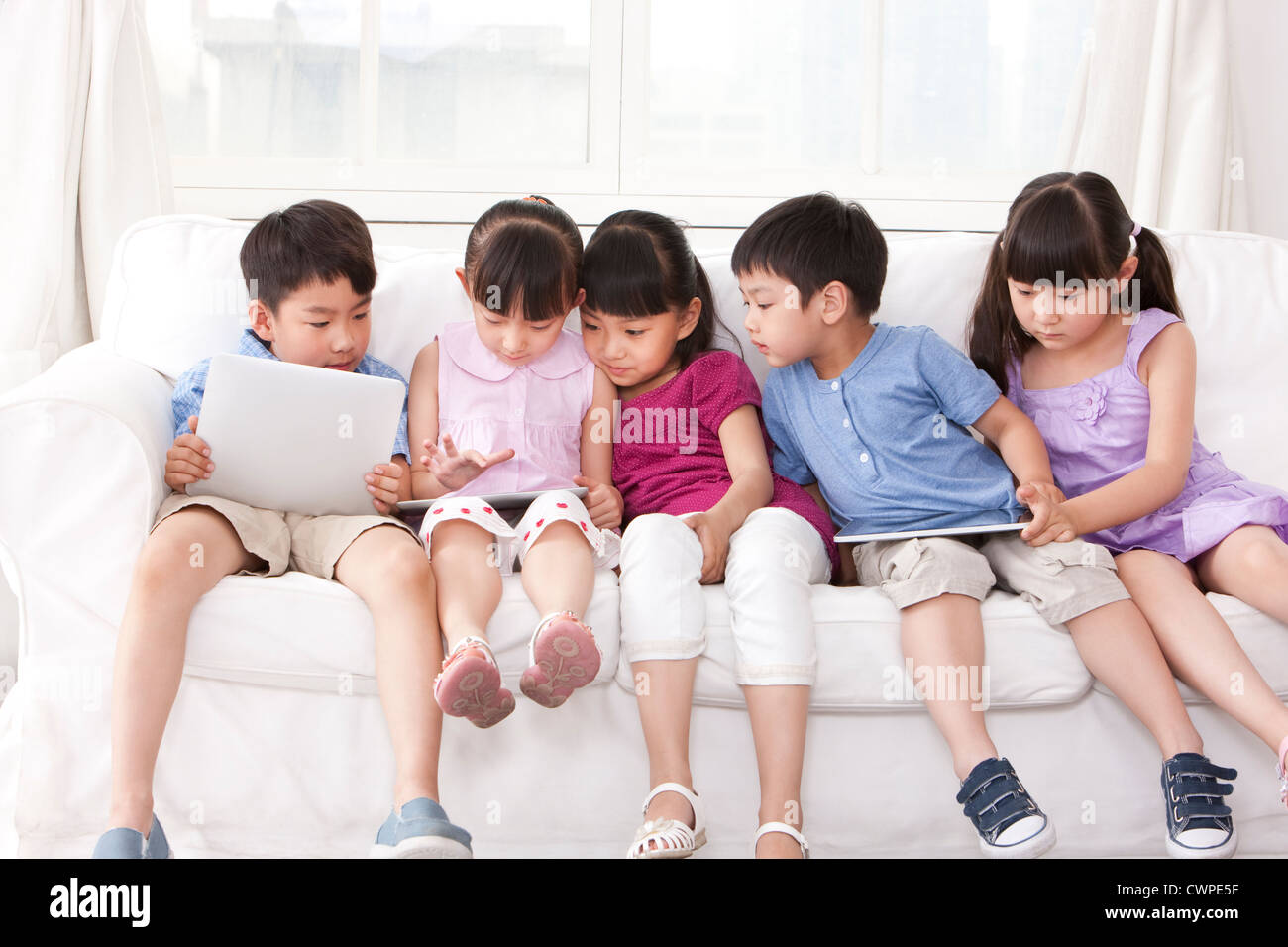 Children playing digital tablet at home Stock Photo - Alamy