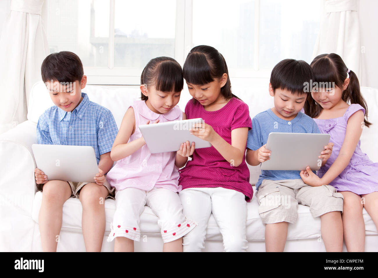 Children playing digital tablet at home Stock Photo - Alamy