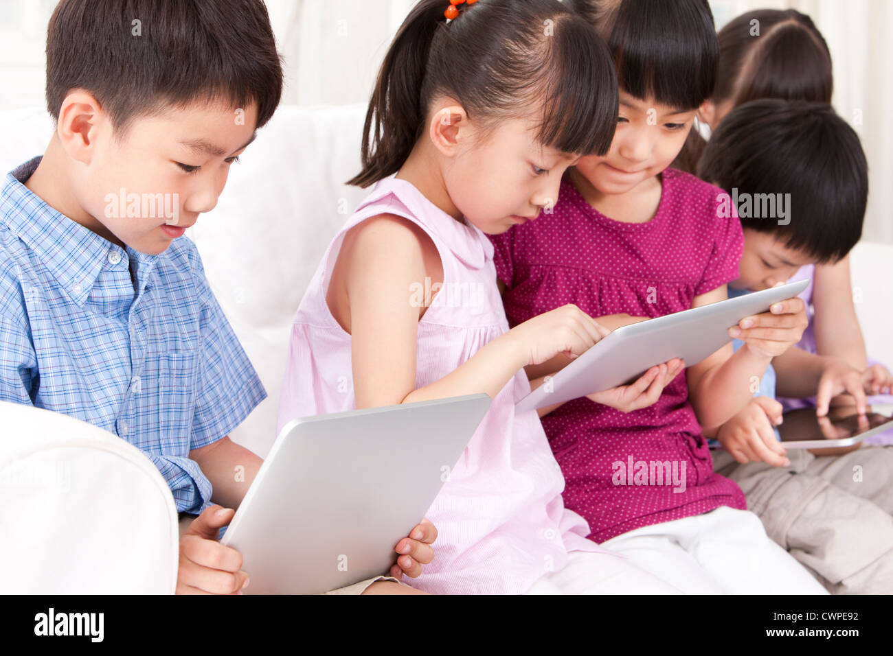 Children playing digital tablet at home Stock Photo - Alamy