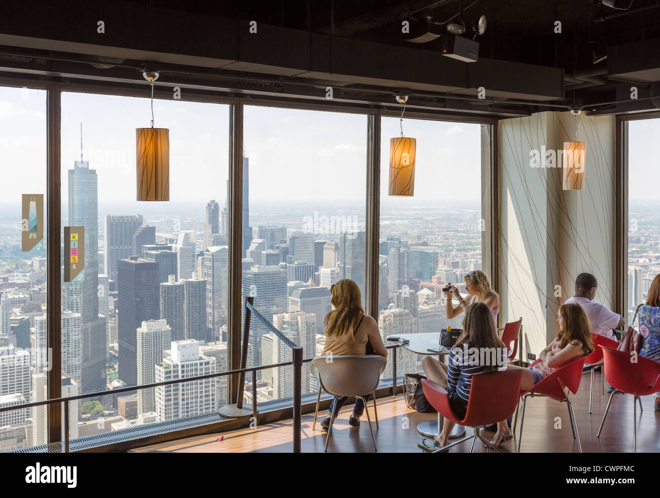 Tourists looking out over city skyline from the 360 Chicago observatory ...