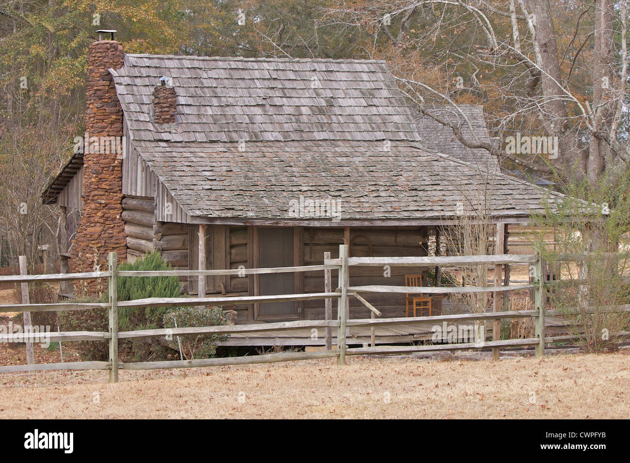 Log cabin with a split rail fence and a dirt road in front Stock Photo ...