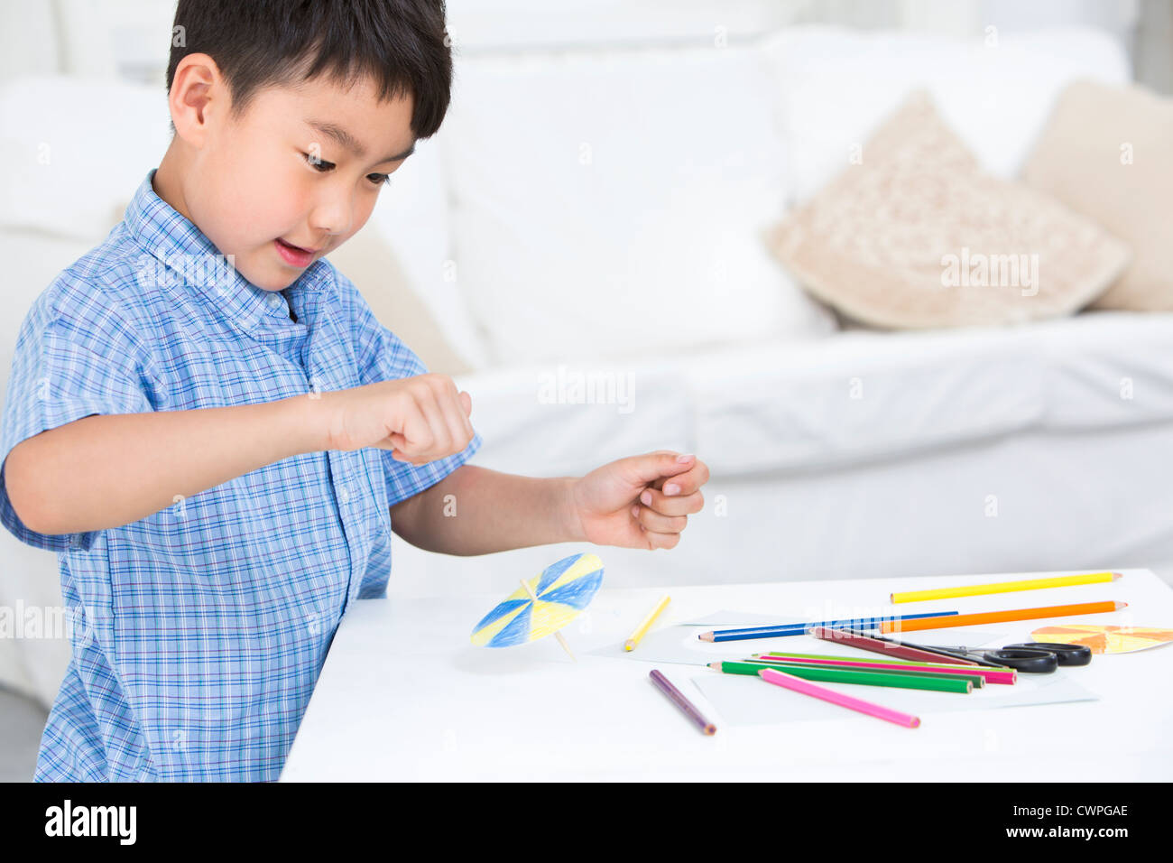 Boy making a paper toy Stock Photo - Alamy