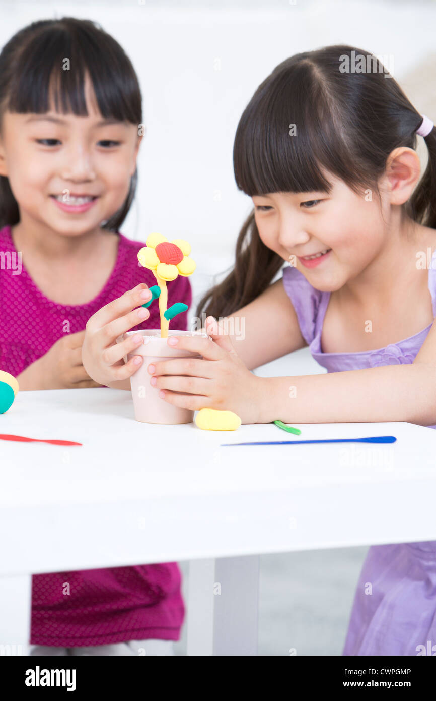 Girls playing child's play clay Stock Photo - Alamy