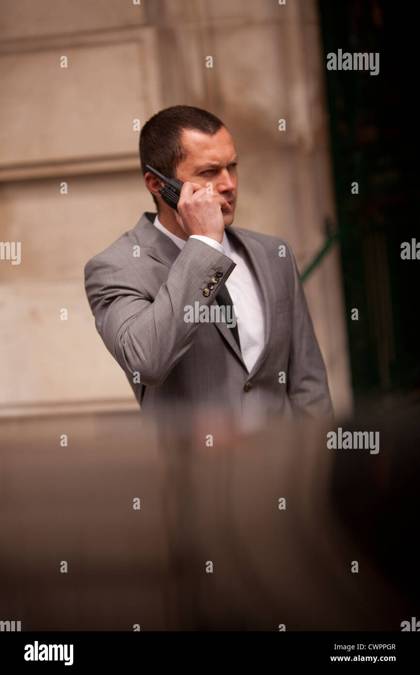 A security close protection officer checking security arrangements with ...