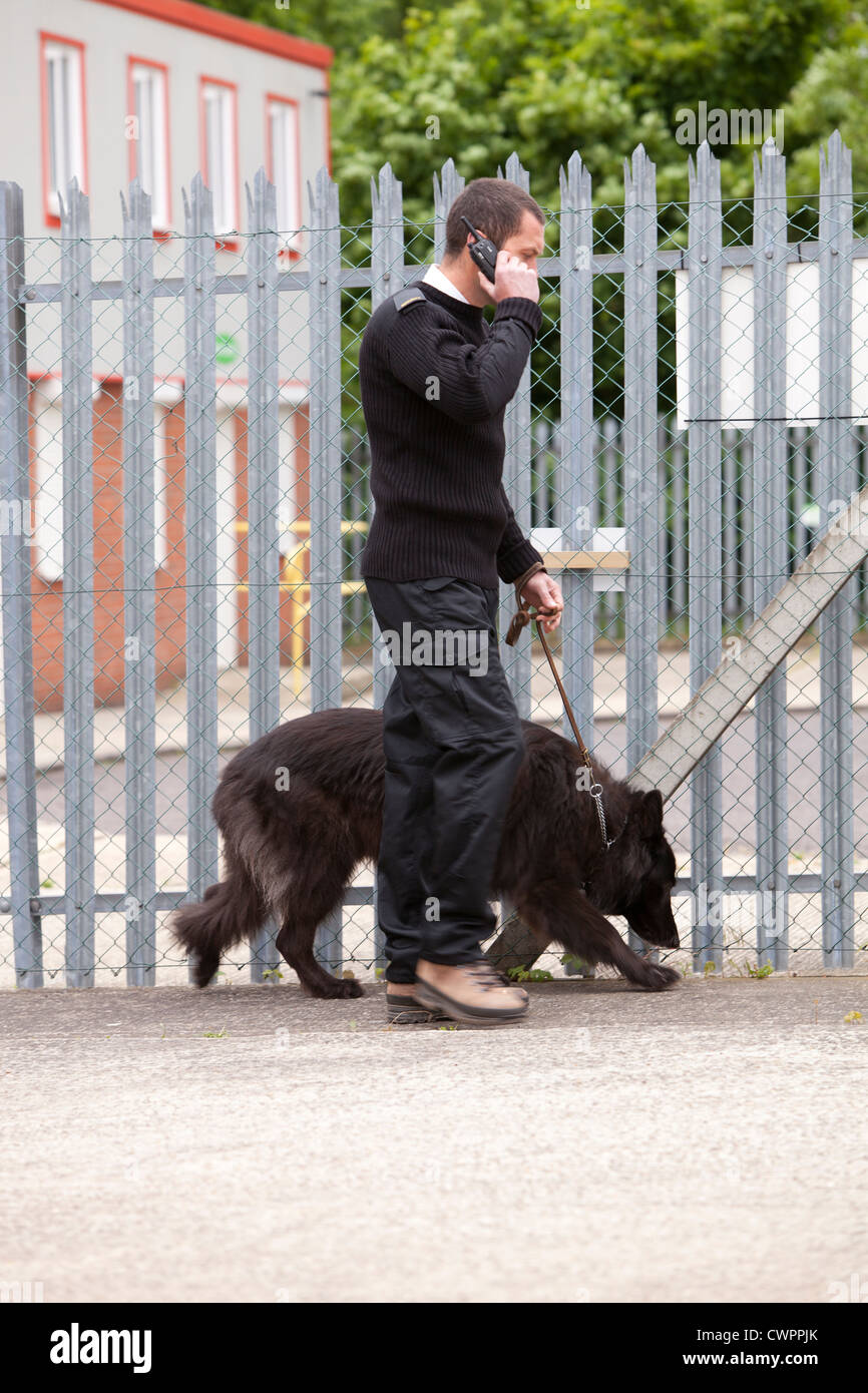 A security guard and guard dog patrolling perimeter fences Stock Photo ...