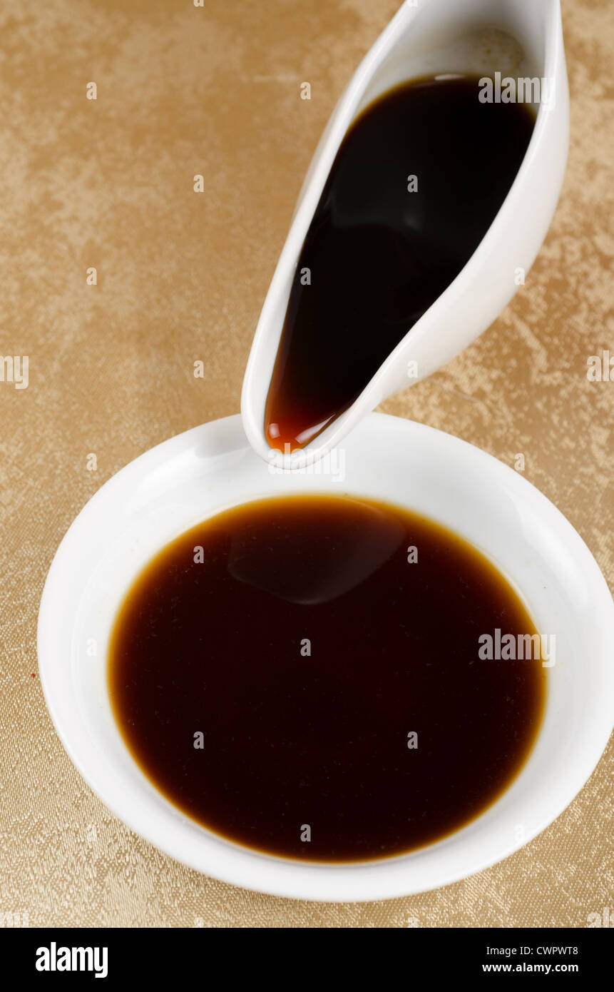 soy sauce poured to a white plate Stock Photo - Alamy