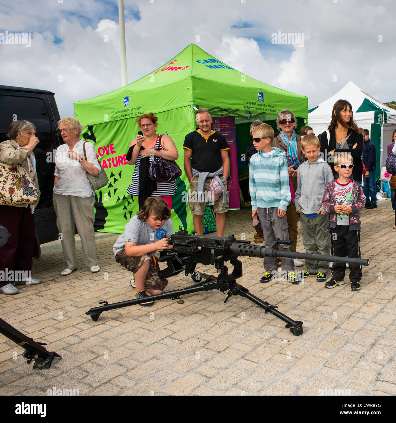 Children playing with a heavy machine gun at an army information stand ...