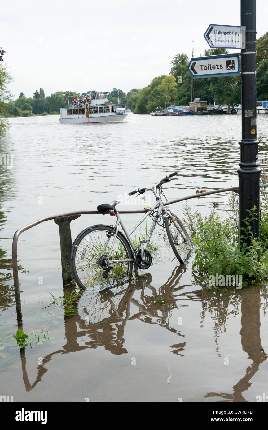 A cycle tied to railings flooded by high tide on the river Thames at ...