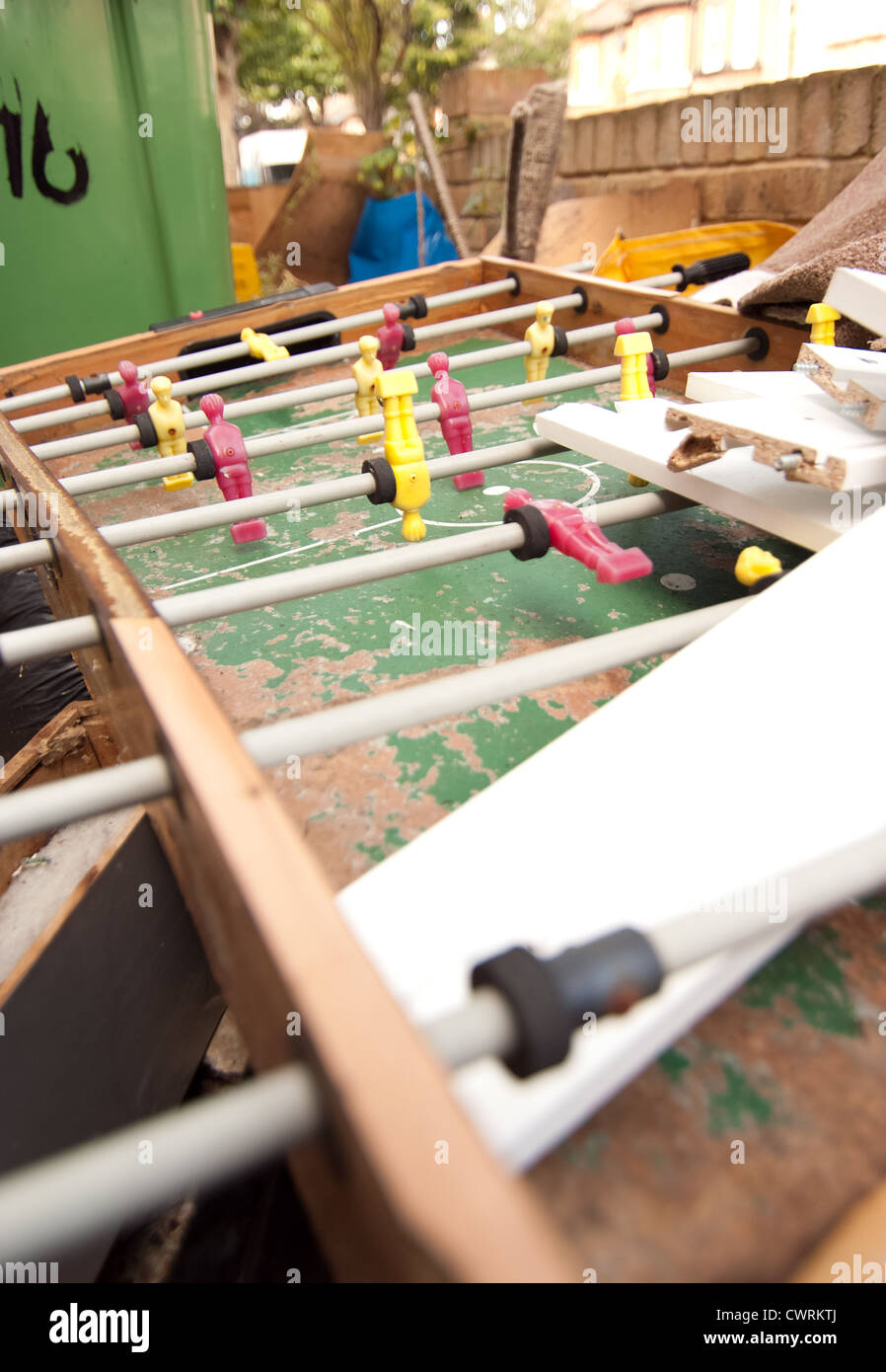 a table football game dumped amongst other rubbish Stock Photo - Alamy