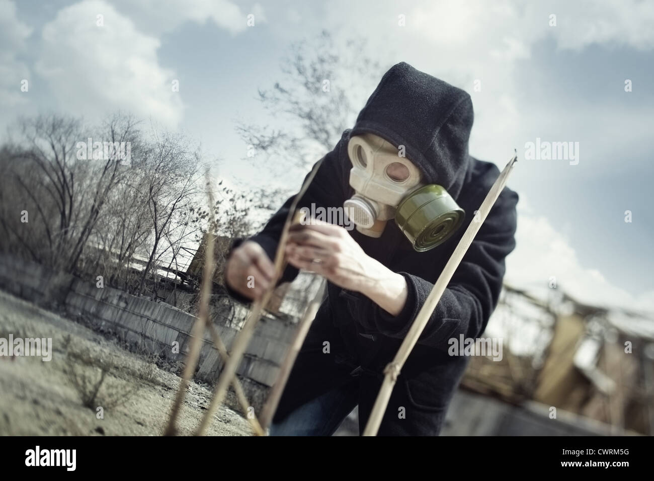 Human in protective gas mask working with dead vegetation Stock Photo ...