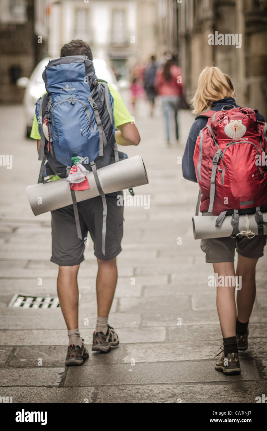 Backpacking pilgrims walking through the streets of Santigo de ...