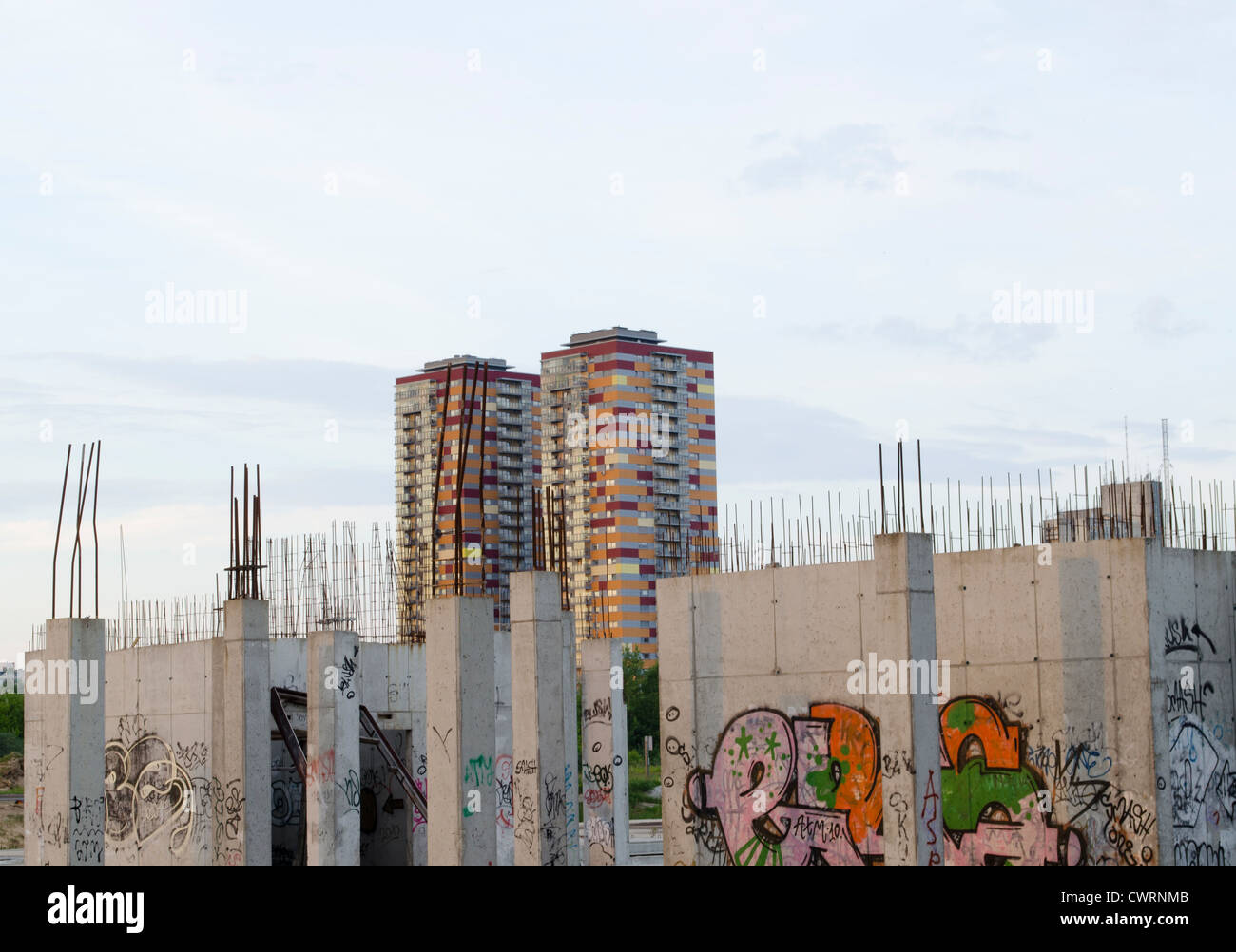 Unfinished building design painted graffiti and two tall skyscrapers in ...