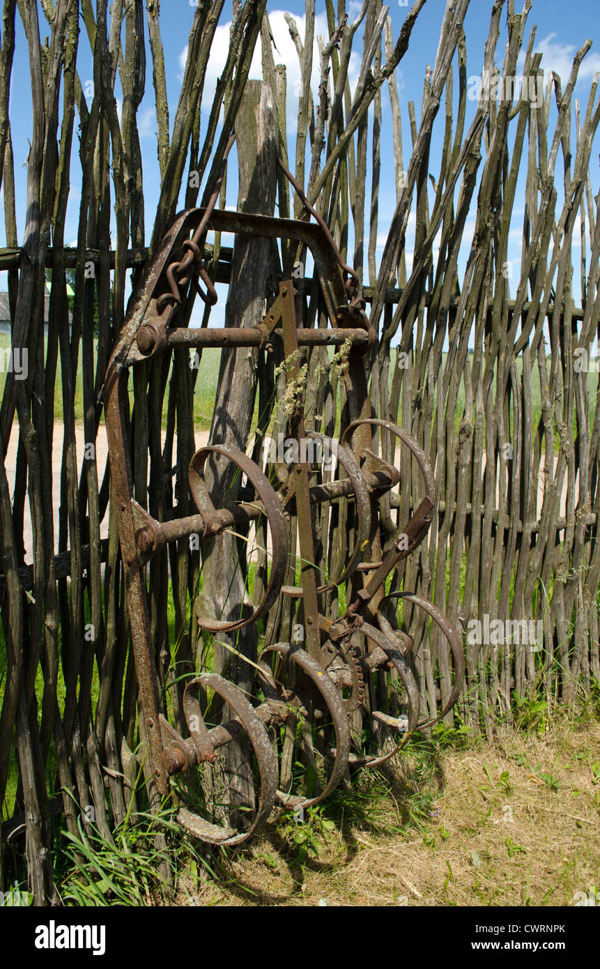 Old corroded harrowing field the tool stand near handmade fence from ...