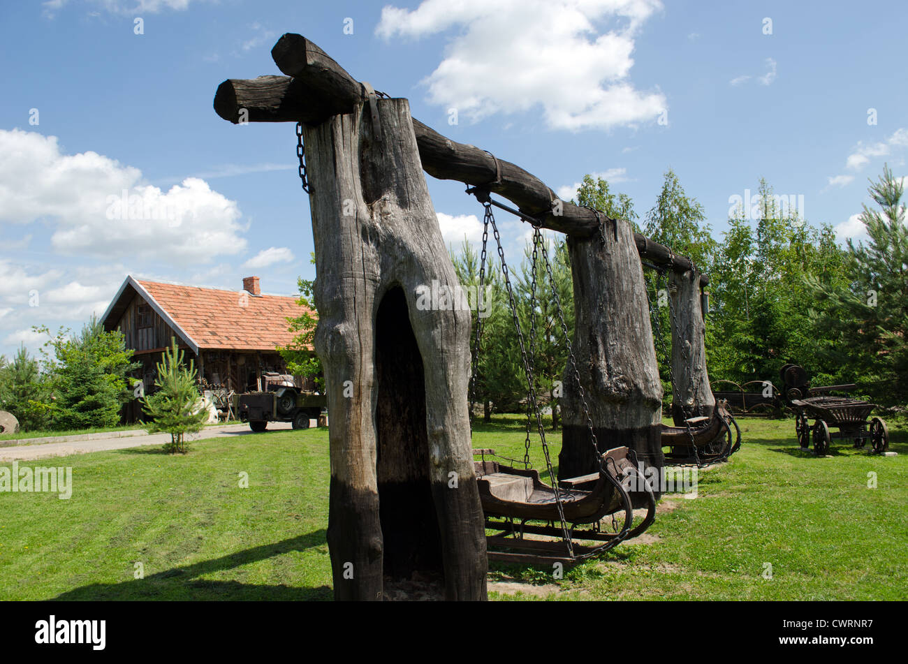 Retro swing made of carriage hang on chains on old tree trunks in park ...