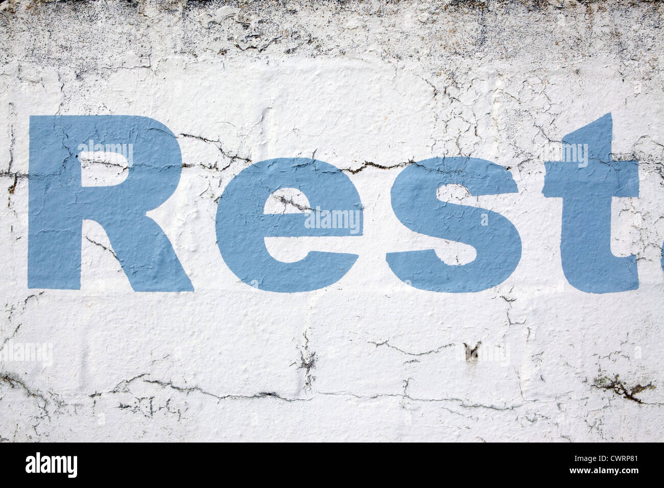 Lettering "Rest", stencil style sky blue paint on a white washed wall ...