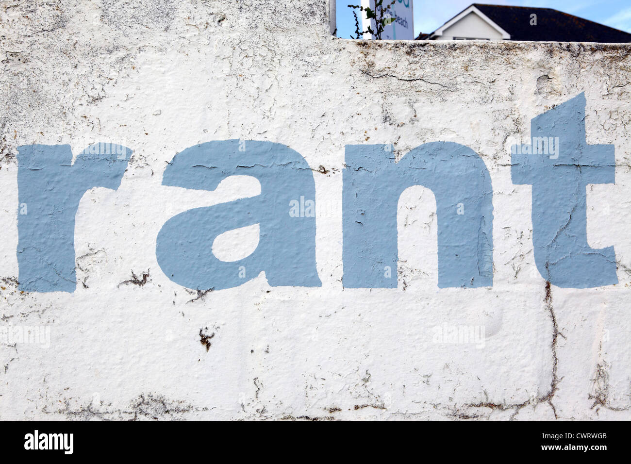 Lettering "rant", stencil style sky blue paint on a white washed wall ...