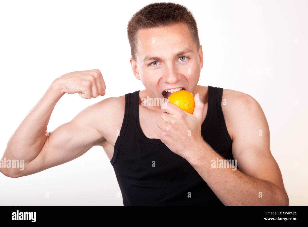 Portrait of a young attractive male eating orange Stock Photo - Alamy
