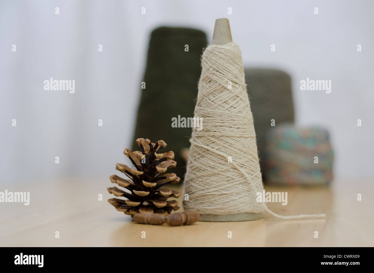 Wool Yarn spools in earthy colours with fircone Stock Photo - Alamy