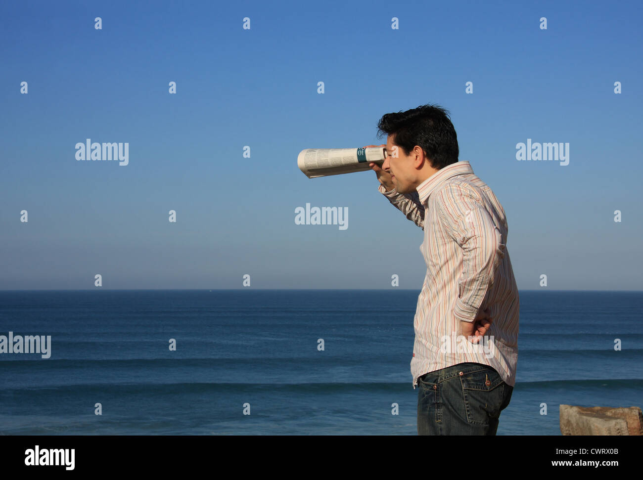 Young man trying to see something with a newspaper binocular Stock ...