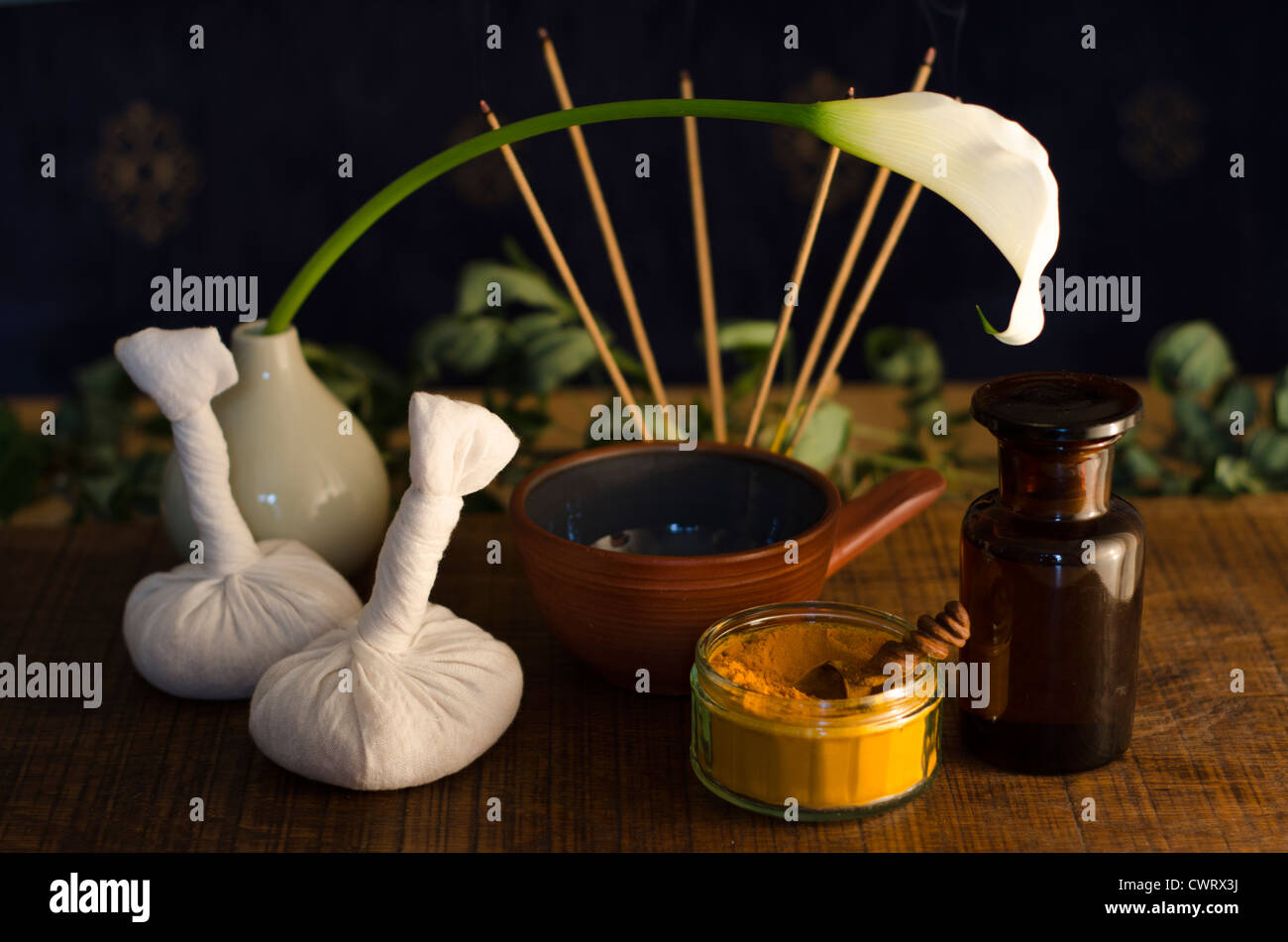 An arrangement of turmeric, spice, oil bowl and bottle, and massage ...