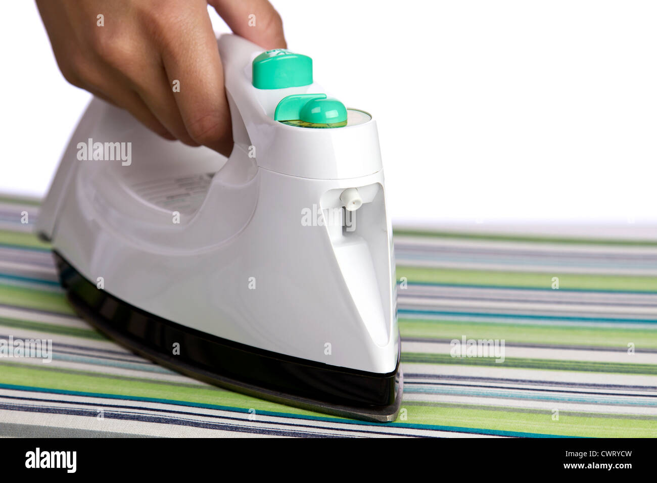 Woman's hand holding hot iron on ironing board against white background ...