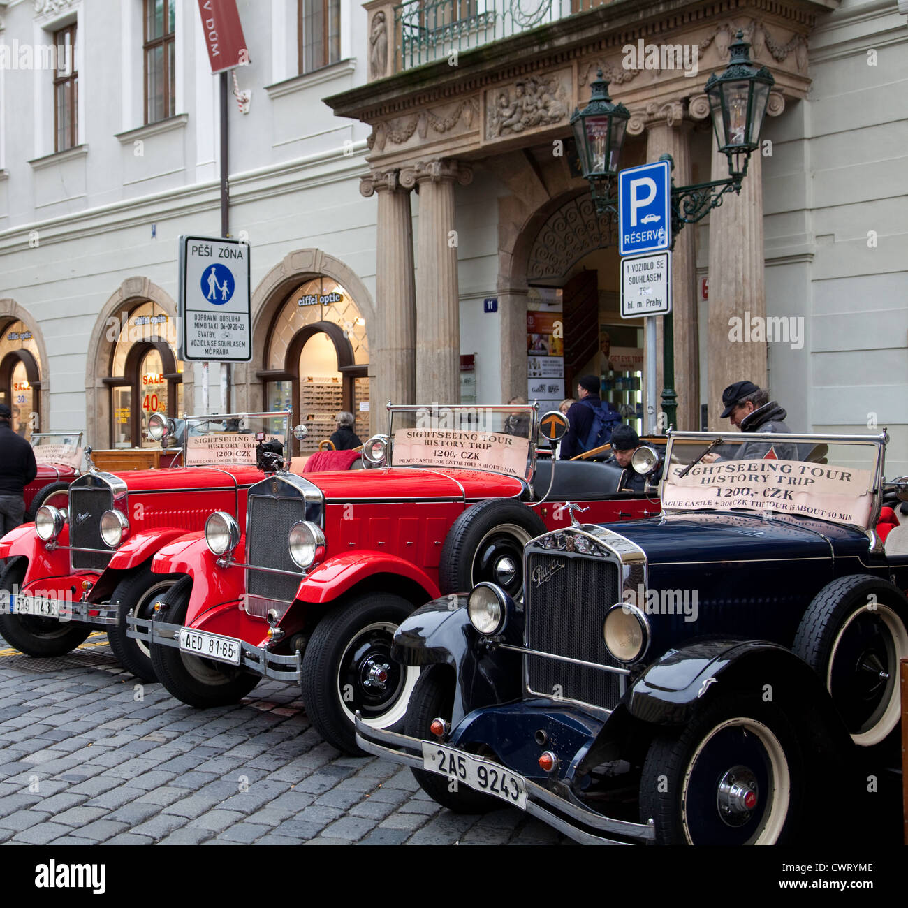 Antique cars await tourists in a small square along Karlova street ...