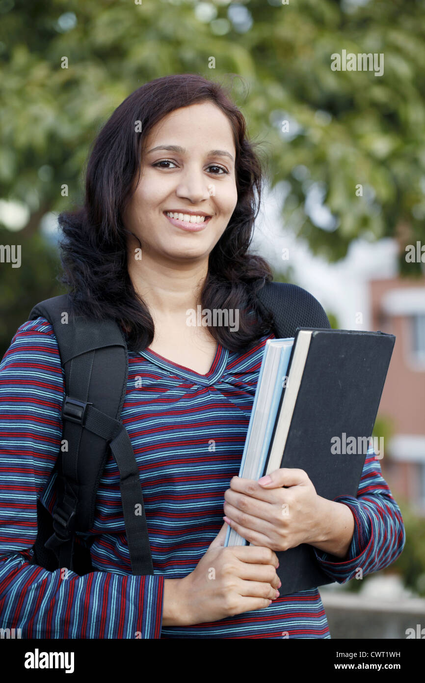 Smiling Indian female student holding books Stock Photo - Alamy