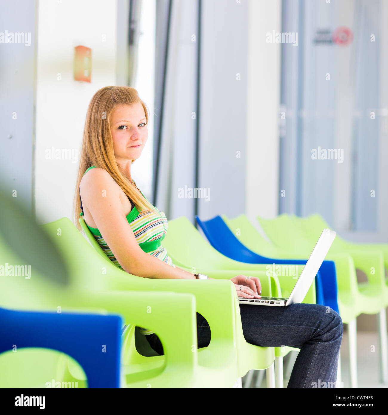 pretty female college student working on her laptop computer on campus ...