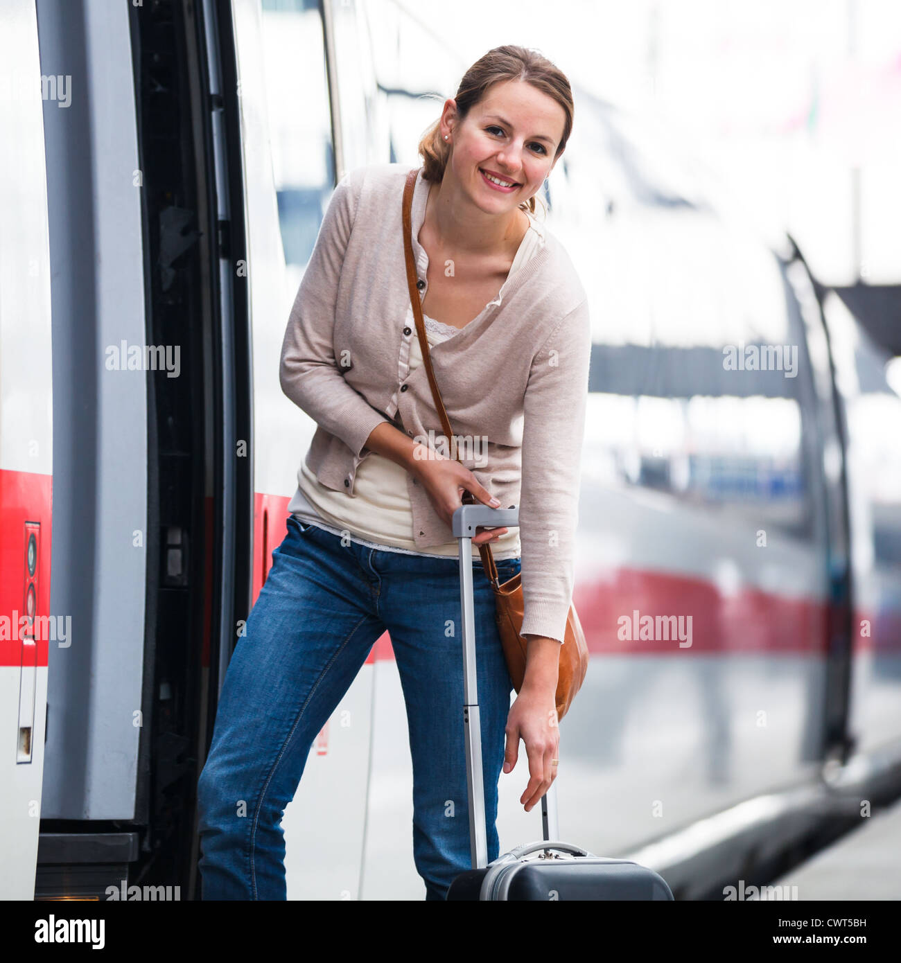 Pretty young woman boarding a train Stock Photo - Alamy