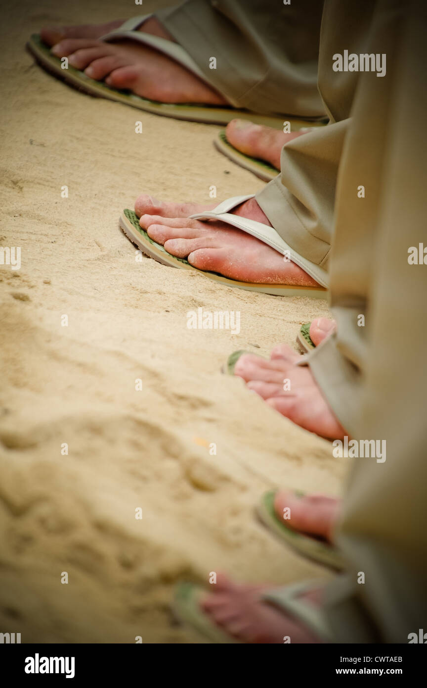 People wearing flip flops standing in a row in sand Stock Photo - Alamy