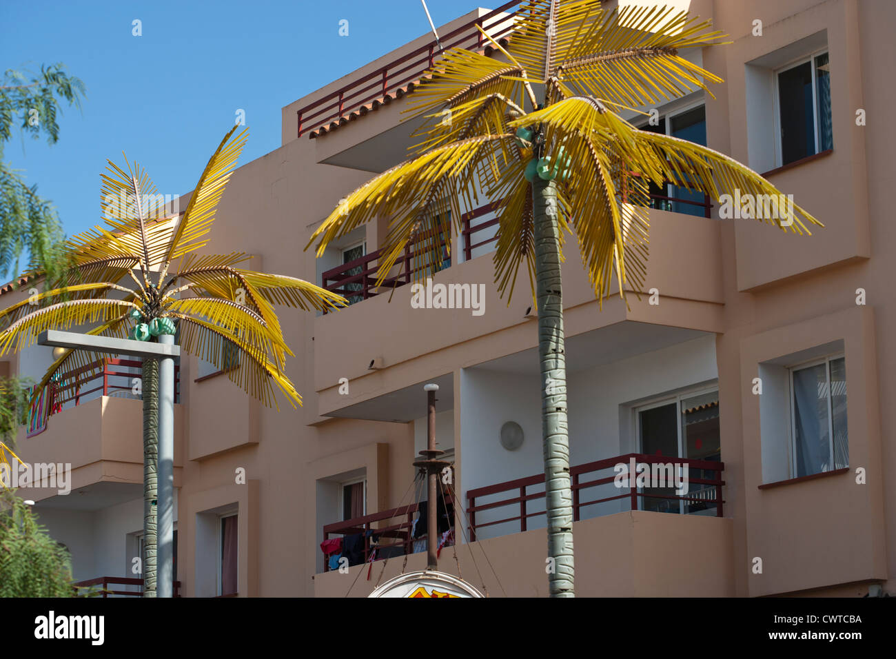 Plastic palm trees outside a tourist apartment block in Ibiza island ...