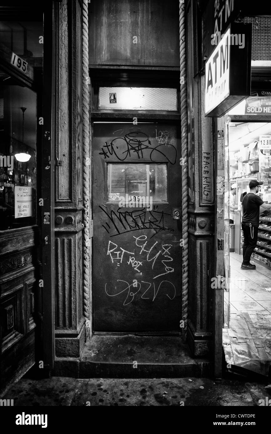 black and white photo of a door next to atm machine in front of a ...