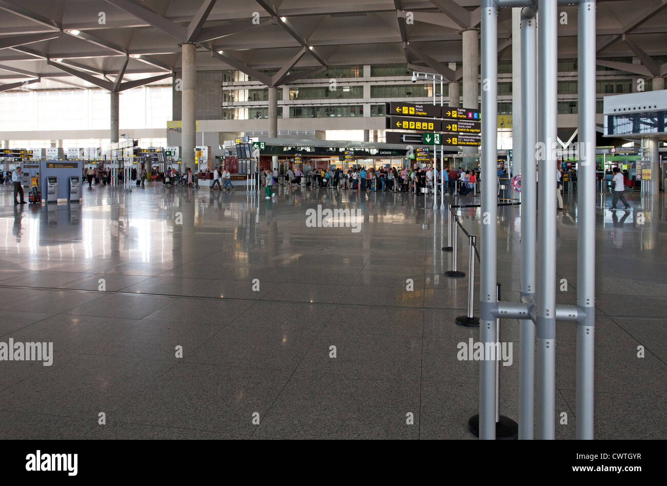 A busy airport terminal concourse with passenger queues in the ...