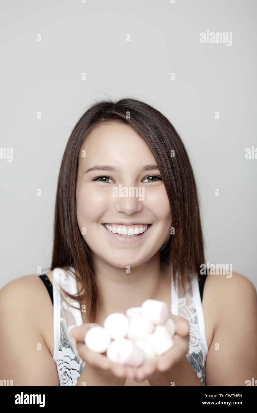 young girl with a handful of marshmallow with a big smile on her face ...